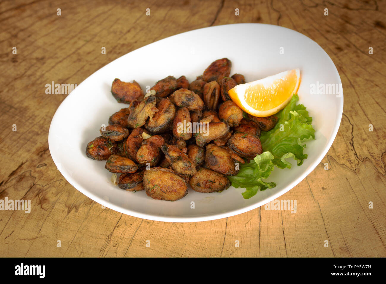 Breaded mussels with dill and garlic, garnished with lettuce leaf and ...