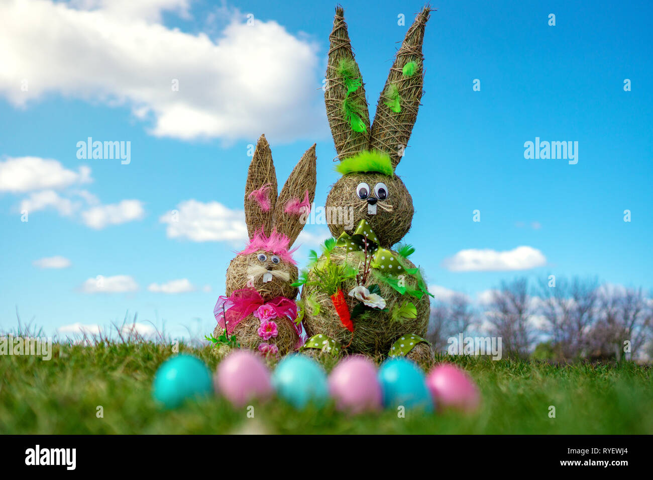 Straw Figure Bunnys With Colorful Easter Eggs green grassand blue sky ...