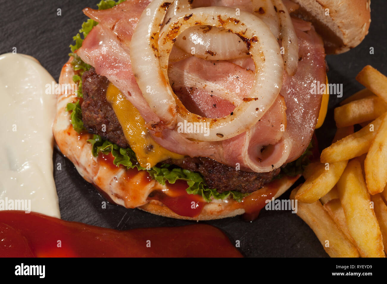 Hamburger with beef meat bacon molten cheese onion rings lettuce french ...