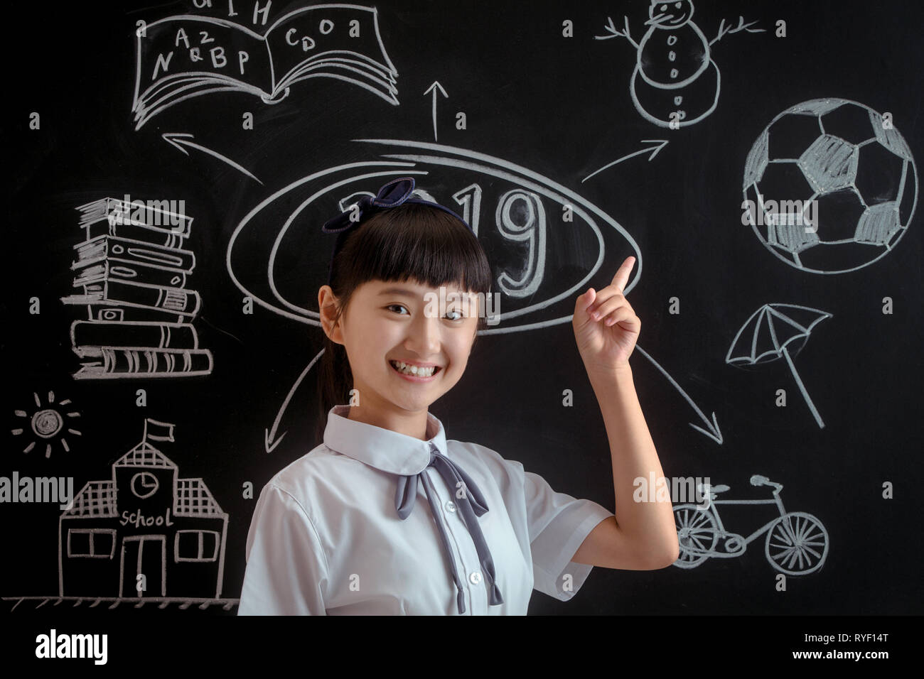 Primary school girl standing in front of the blackboard Stock Photo - Alamy