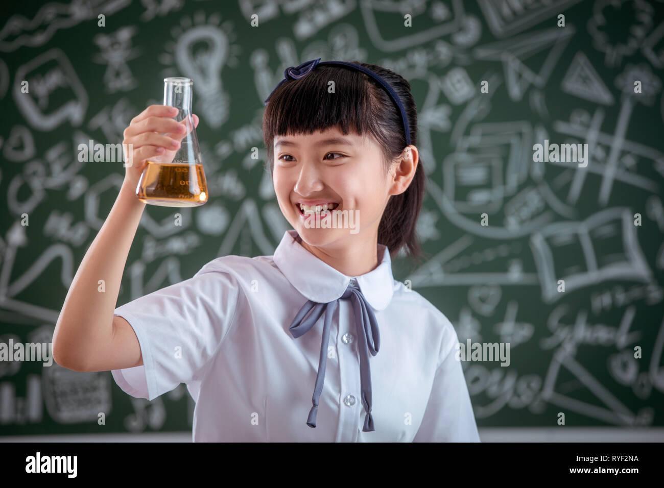 Primary school girls holding a beaker Stock Photo - Alamy