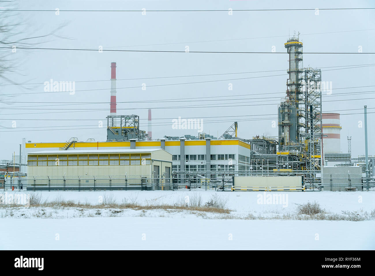 Small oil refinery on the background of the cloudy sky in the winter ...