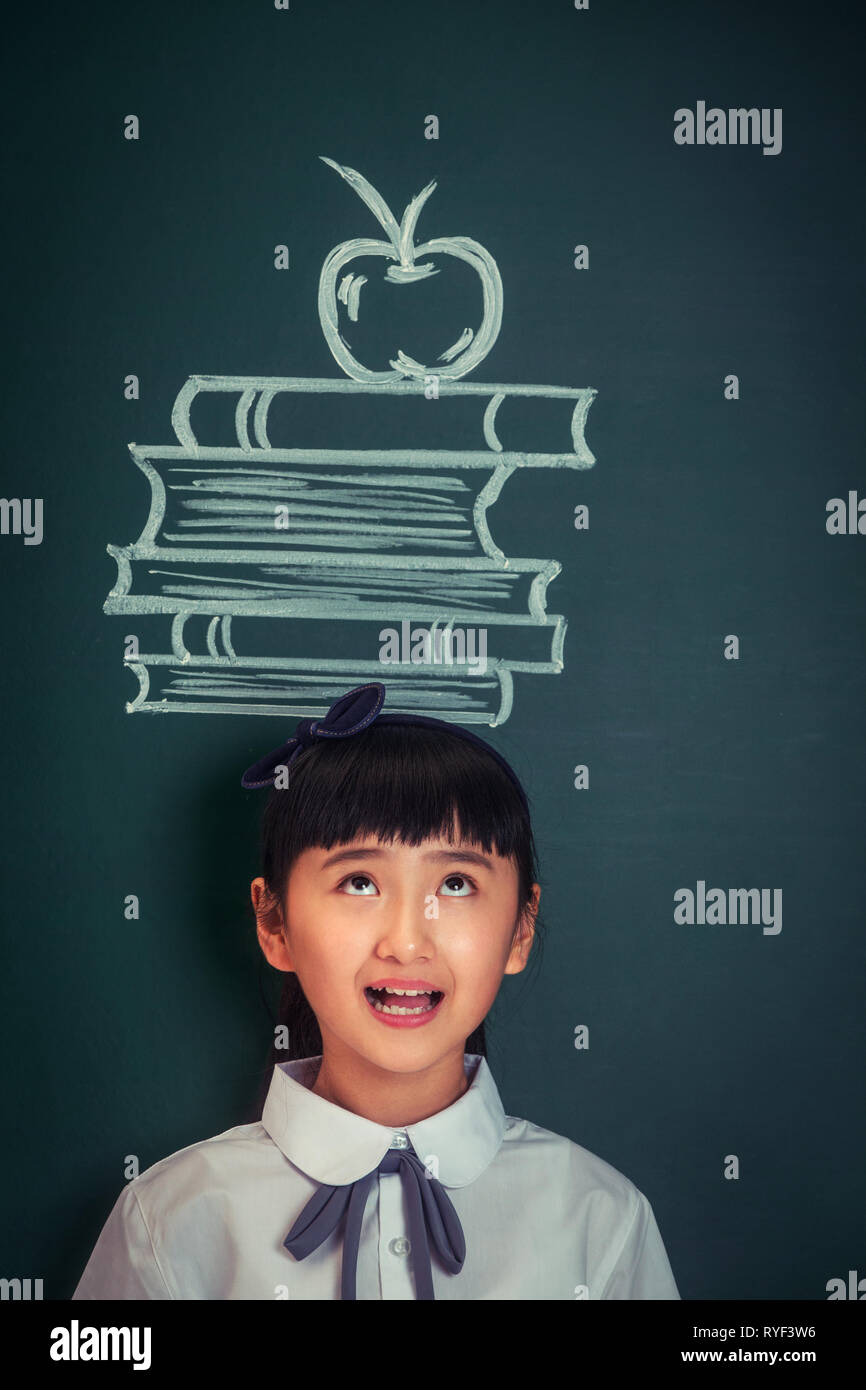 Primary school girl standing in front of the blackboard Stock Photo - Alamy