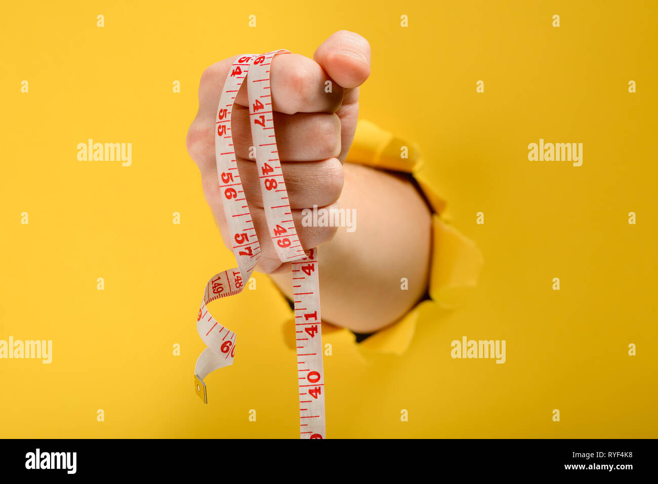 Hand holding a tape measure Stock Photo - Alamy