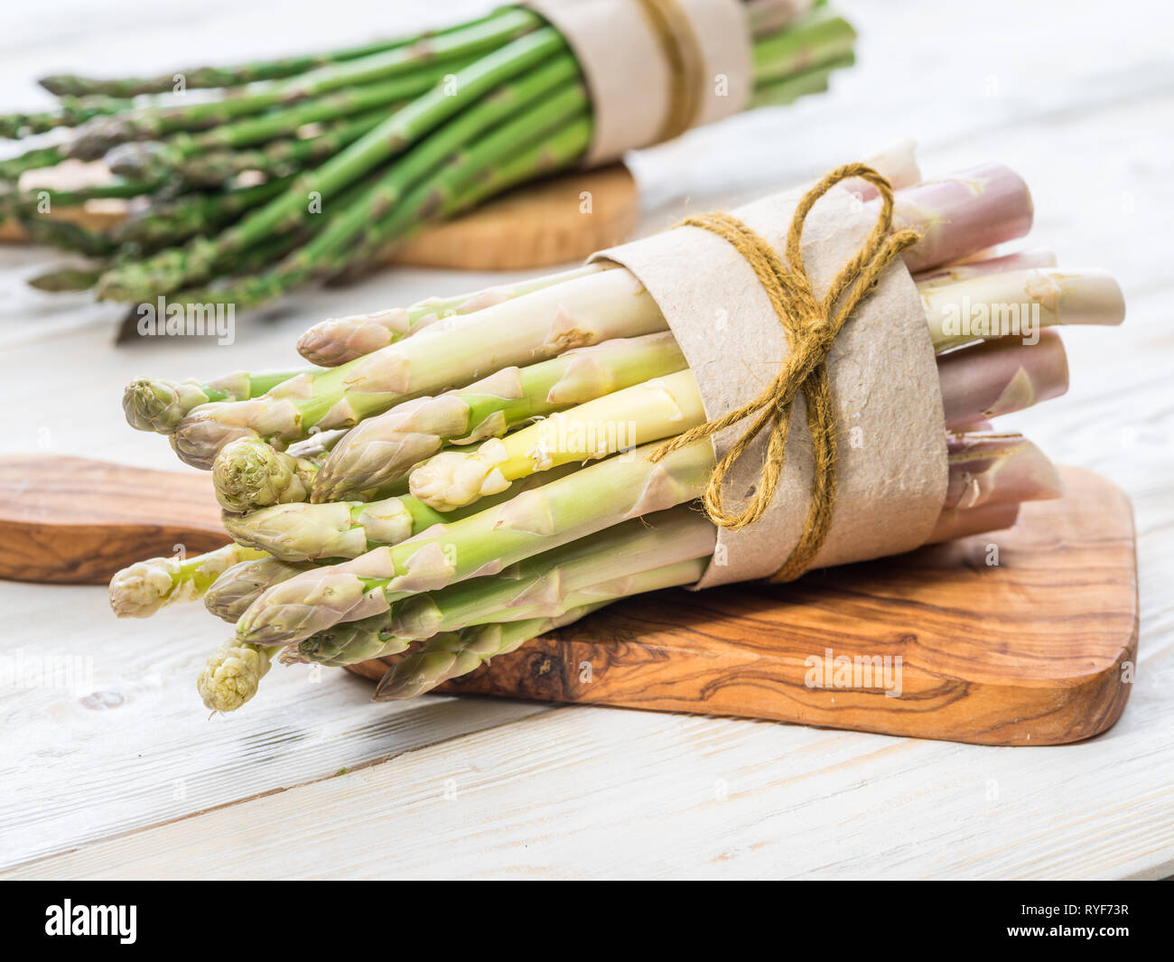 Bundles of green and white asparagus on wooden board. Organic food ...