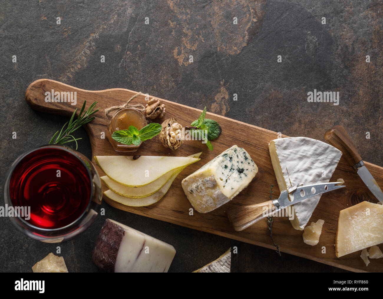Cheese platter with organic cheeses, fruits, nuts and wine on stone ...