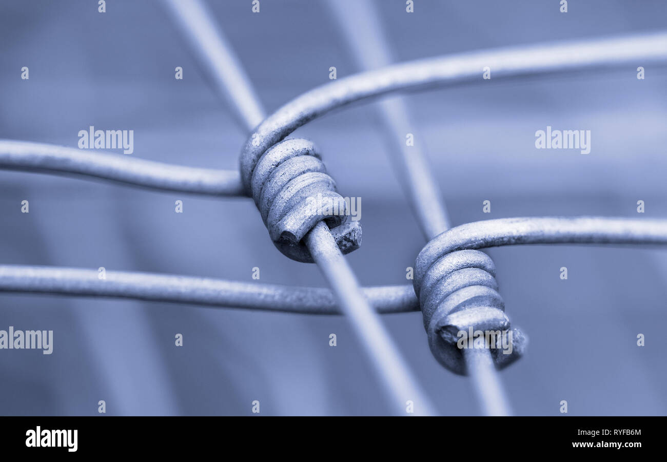 Fixed connection detail. Metallic wire fence. Artistic close-up of ...