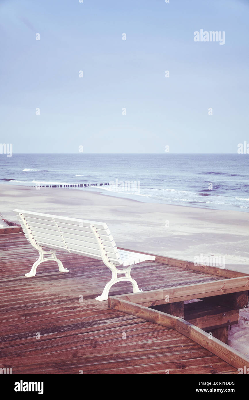 Empty bench on the beachfront, color toned picture Stock Photo - Alamy