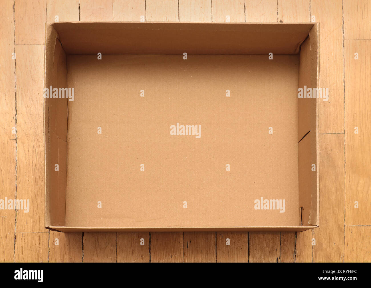 Empty cardboard rectangle box on wooden floor Stock Photo - Alamy
