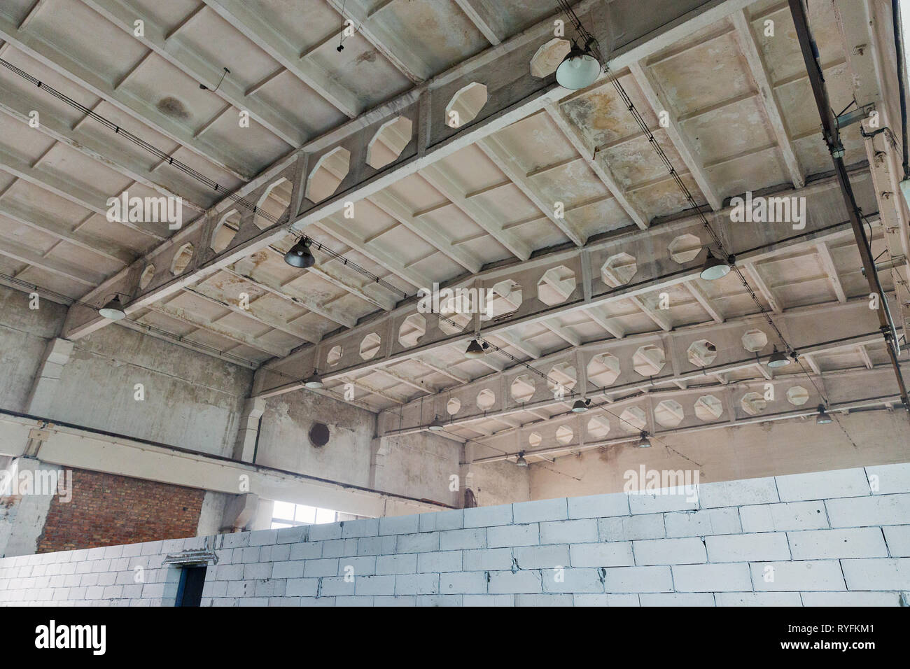 abandoned old factory building inside, ceiling construction elements ...