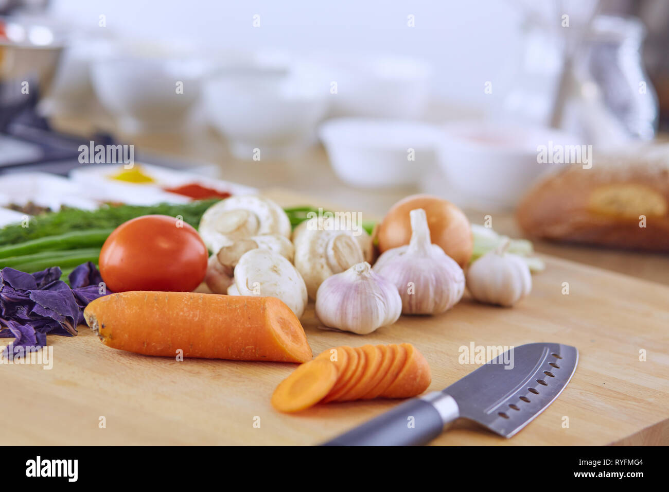 Composition with wooden board and ingredients for cooking on table ...