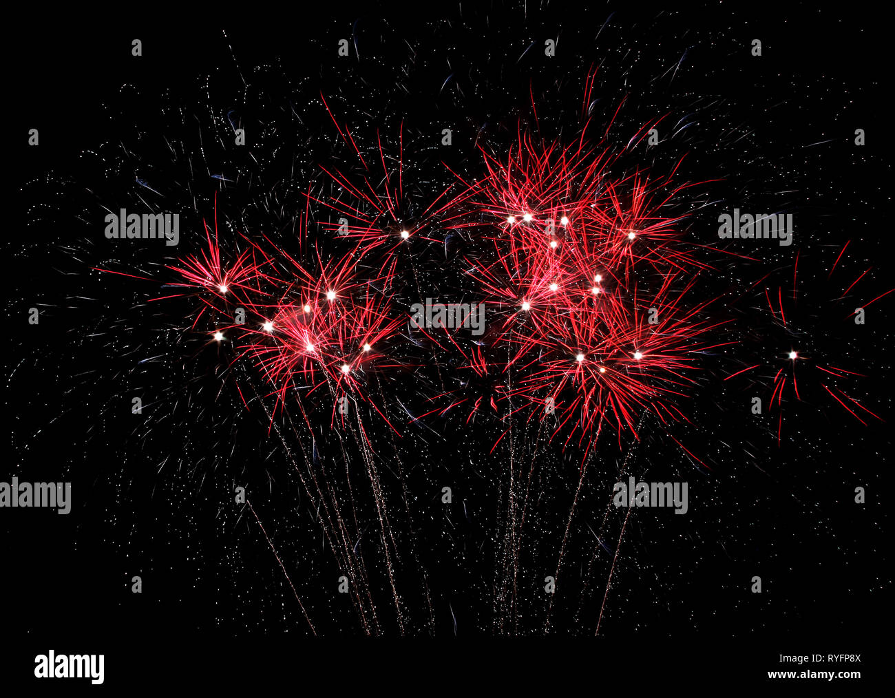 Red fireworks with white highlights light the sky on July 4th, 2015 ...