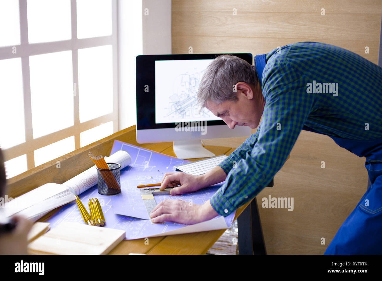 Engineer carpenter working on laptop and sketching project Stock Photo ...