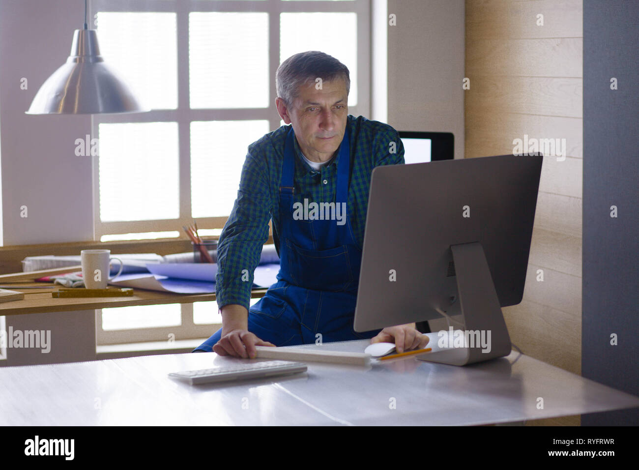 Engineer carpenter working on laptop and sketching project Stock Photo ...