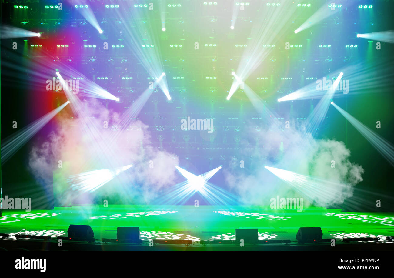 Illuminated empty show stage with fog, green and blue scenic light and ...