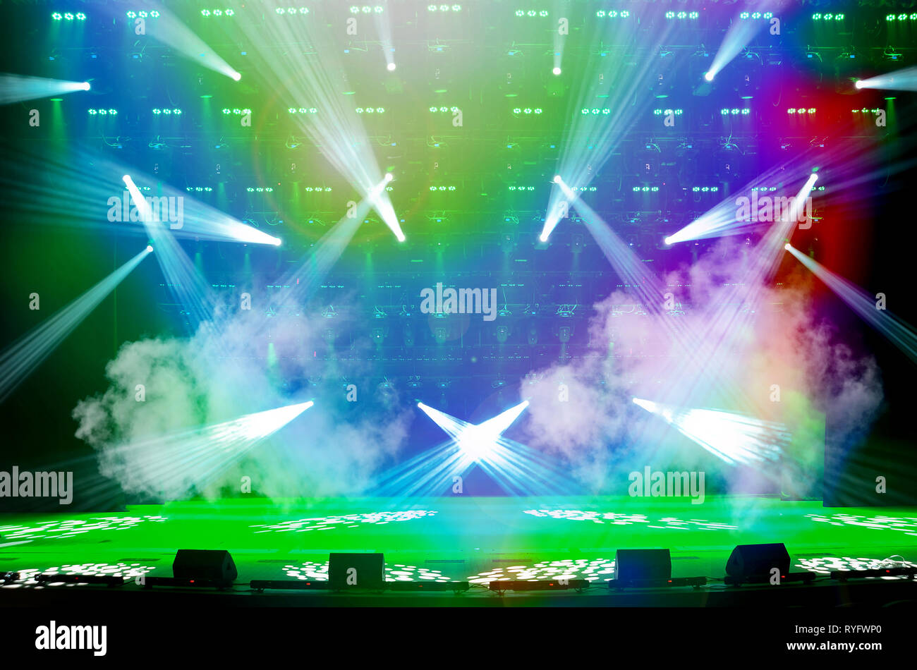 Illuminated empty show stage with fog, green and blue scenic light and ...