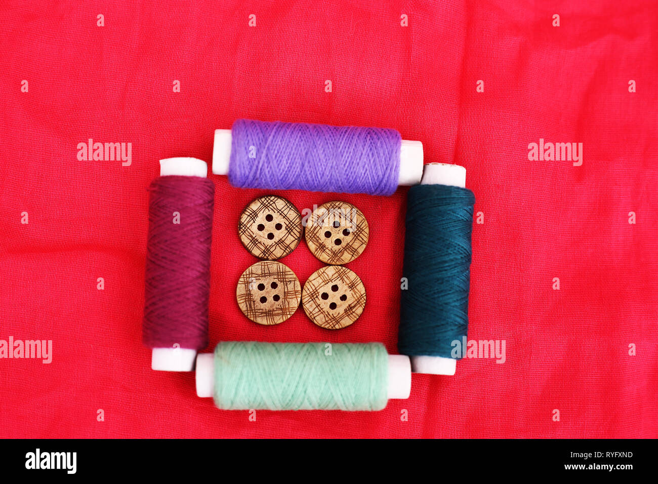 Picture of multicolored Sewing thread and button. Isolated on the red ...