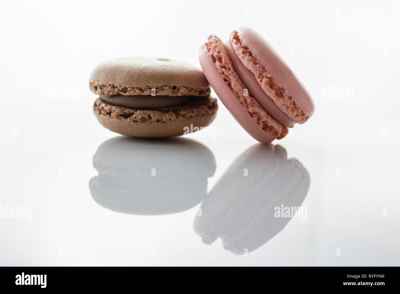 Brown and pink macaroons isolated on white background Stock Photo - Alamy