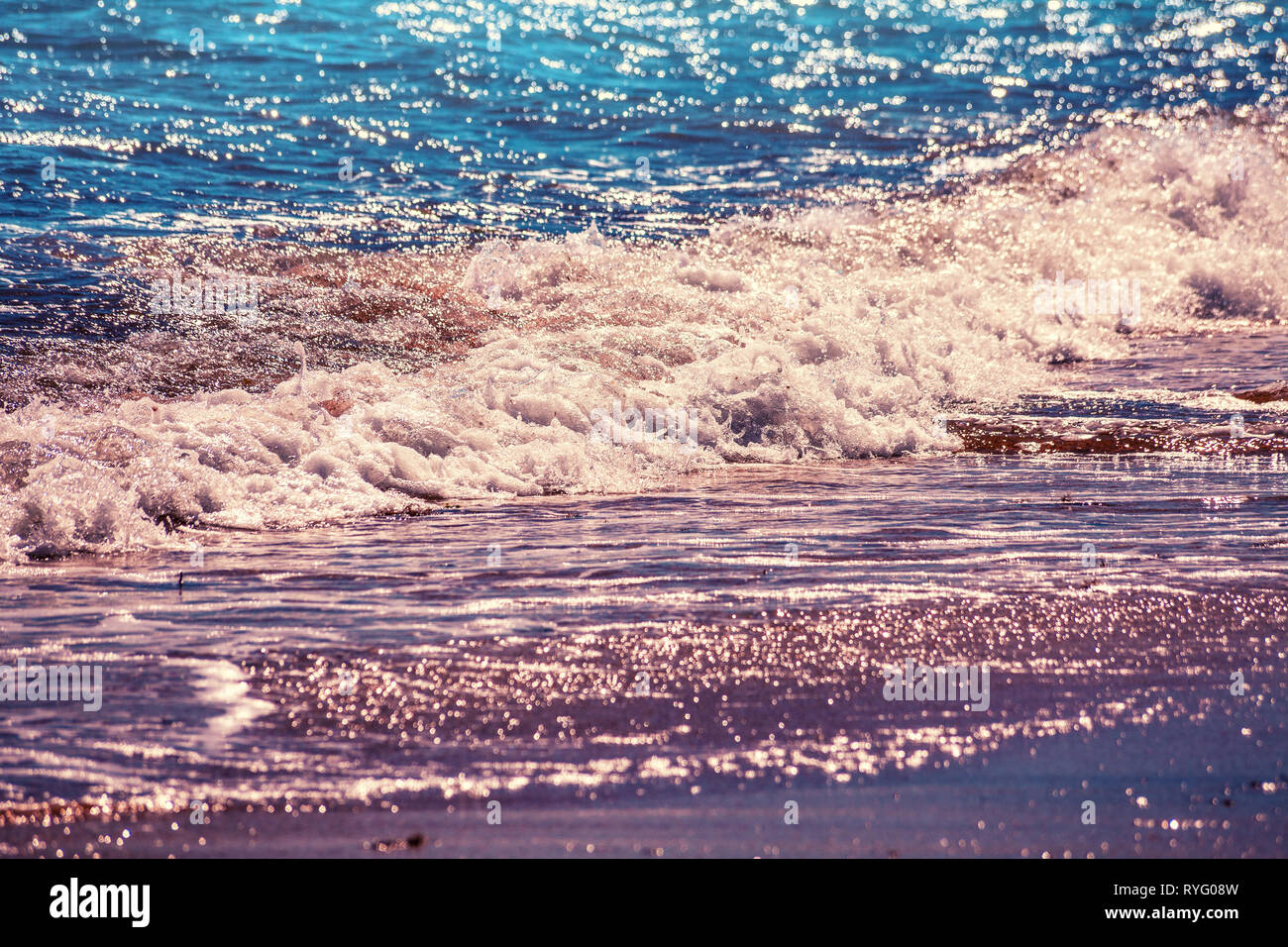 The wave rolls over the pebble beach. Stony coast in summer. Beautiful ...