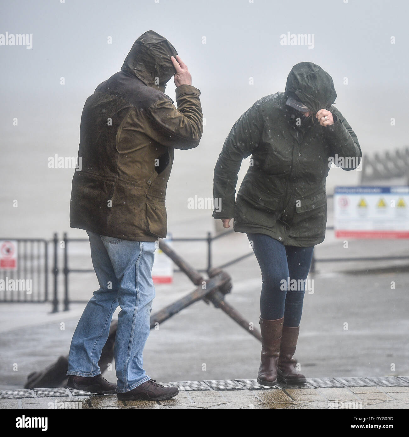 People Are Buffeted With Wind And Rain On The Harbour Wall At Porthcawl