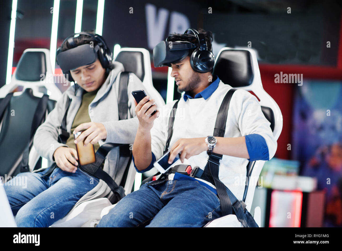 Two young indian people having fun with a new technology of a vr ...