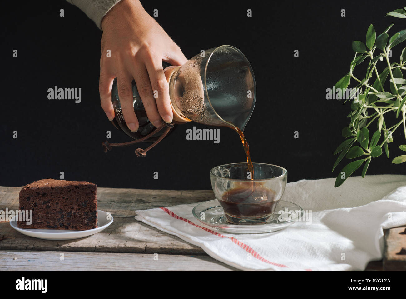 Man pouring cold brew coffee into glass on table Stock Photo - Alamy