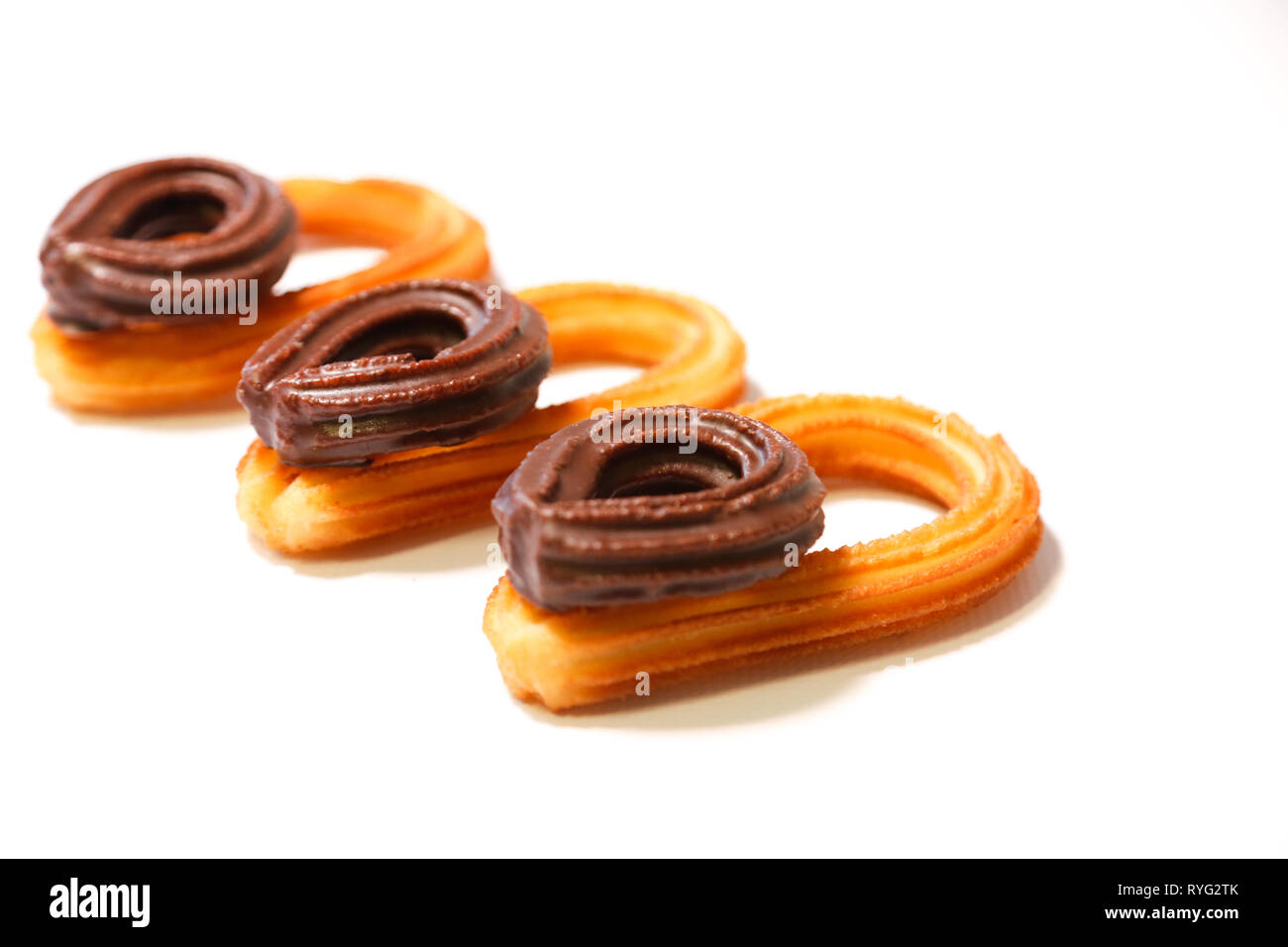 spanish fritters with small chocolate fritters on top on white ...