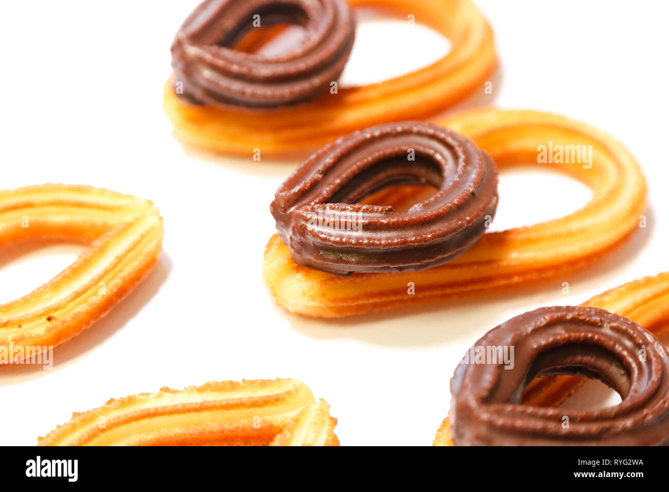 spanish fritters with small chocolate fritters on top on white ...