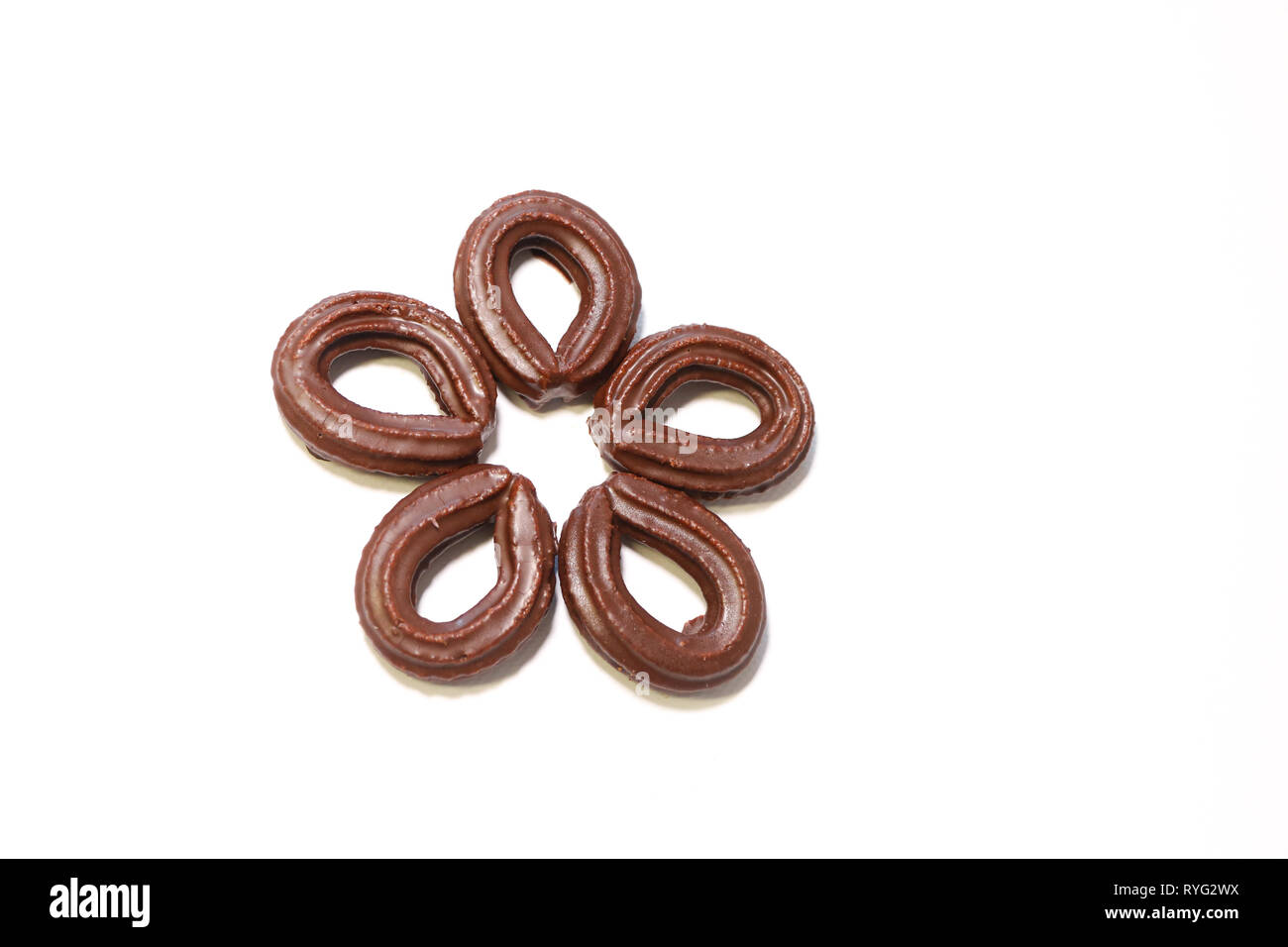 small chocolate spanish fritters on flower shape on white background ...