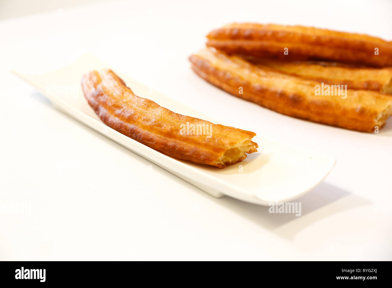 spanish fritters on white dish with white background Stock Photo - Alamy