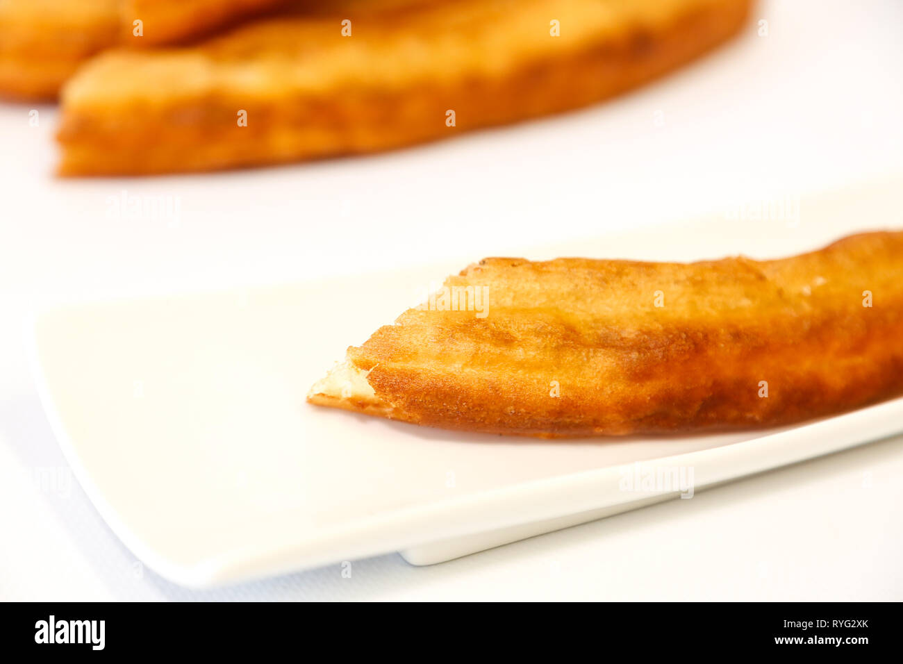 spanish fritters on white dish with white background Stock Photo - Alamy