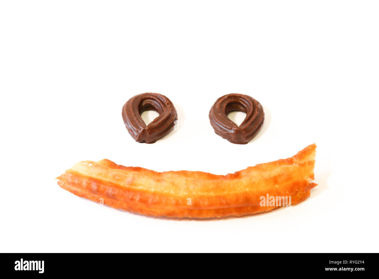 spanish fritters on a smiley face with white background Stock Photo - Alamy