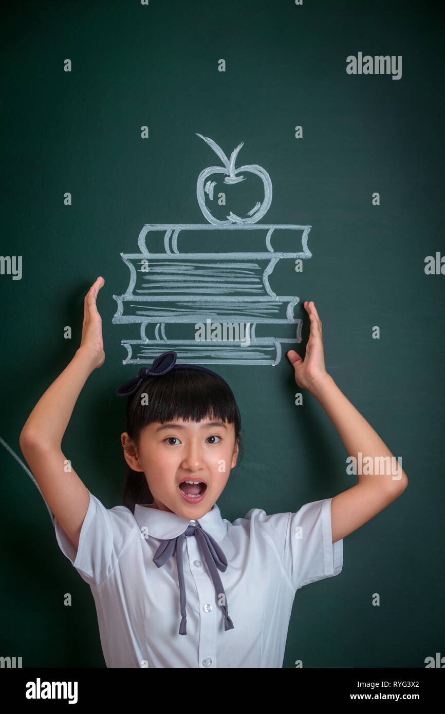 Primary school girl standing in front of the blackboard Stock Photo - Alamy