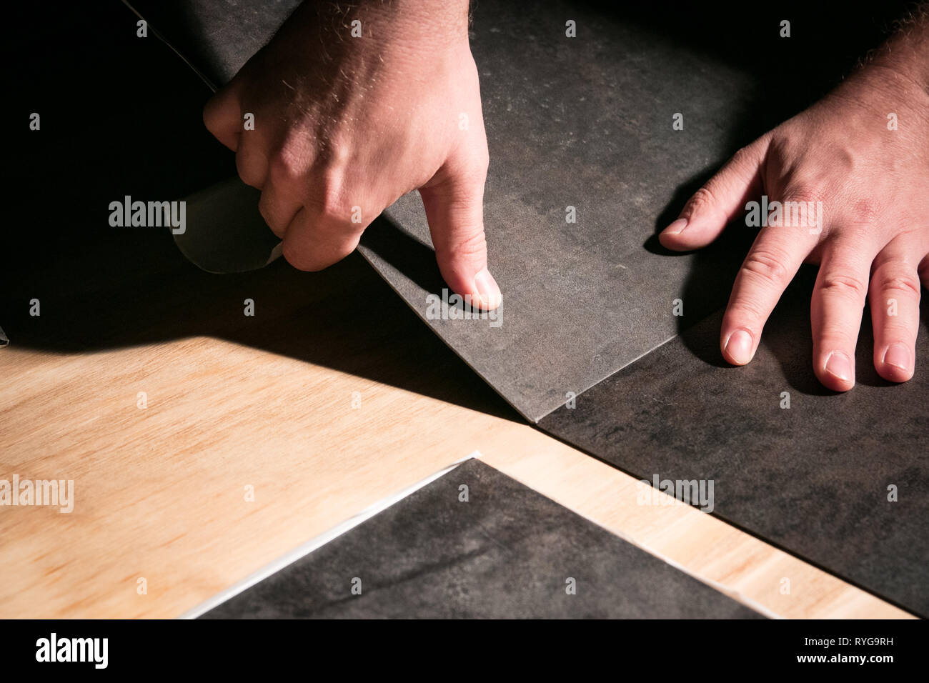 Hand installation of vinyl flooring tiles Stock Photo - Alamy