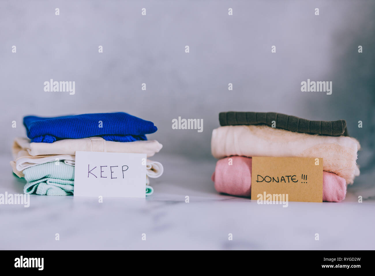 decluttering and tidying up concept: piles of tshirts and clothes being ...