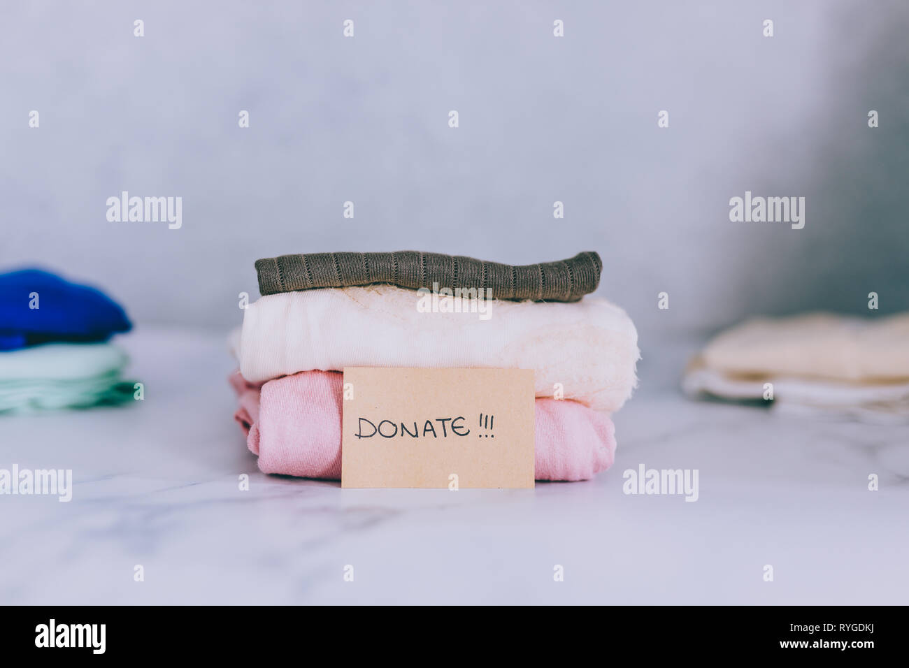 decluttering and tidying up concept: piles of tshirts and clothes being ...