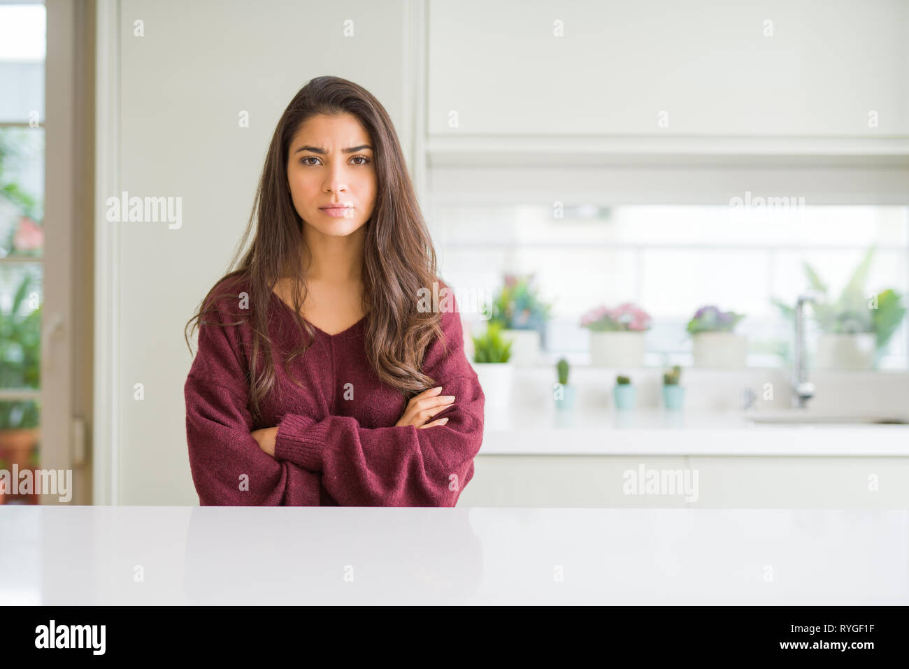 Young beautiful woman at home skeptic and nervous, disapproving expression on face with crossed ...