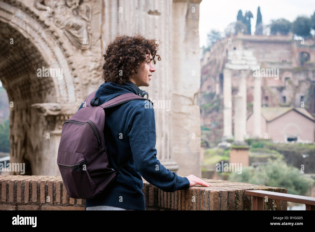 Young man with backpack looking at Roman forum Stock Photo - Alamy
