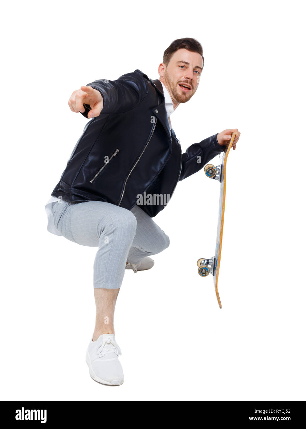A man with a skateboard. A guy in stylish clothes and trousers posing ...
