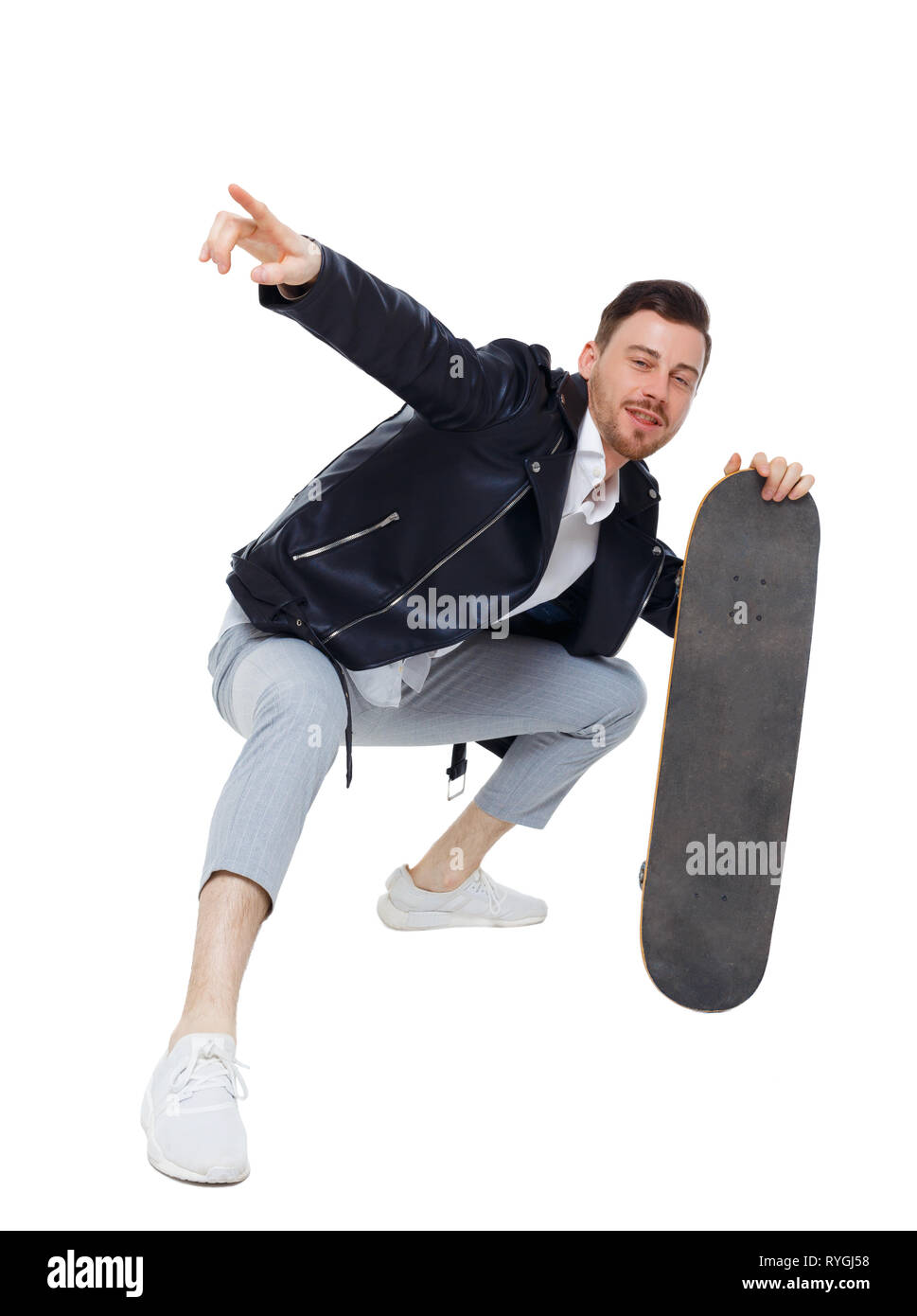 A man with a skateboard. A guy in stylish clothes and trousers posing ...