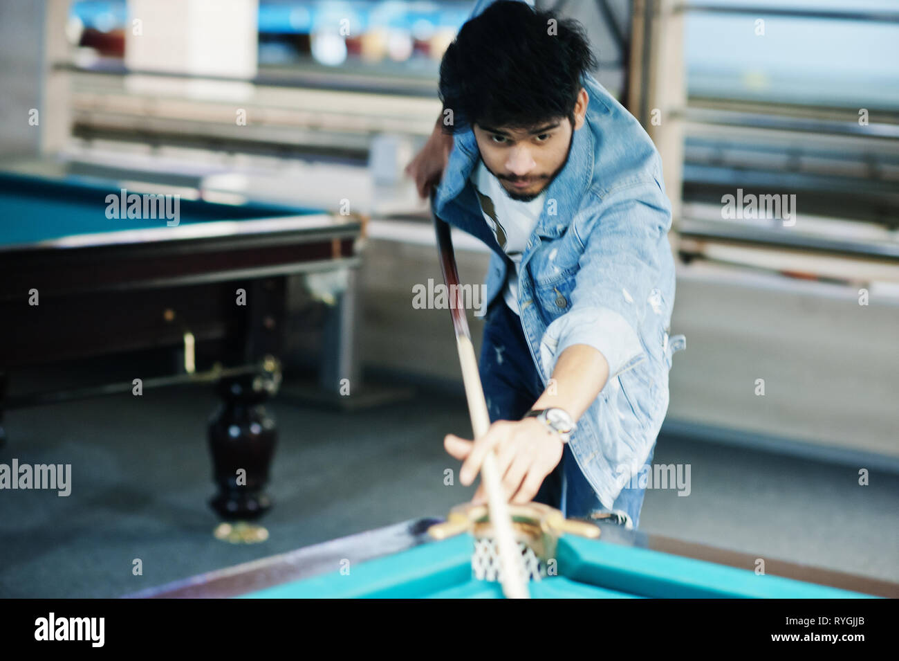 Stylish asian man wear on jeans playing pool billiard on bar Stock ...