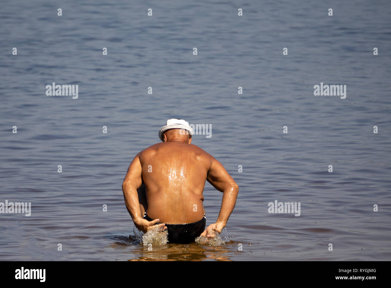Man sitting back on beach sunshine view Stock Photo - Alamy