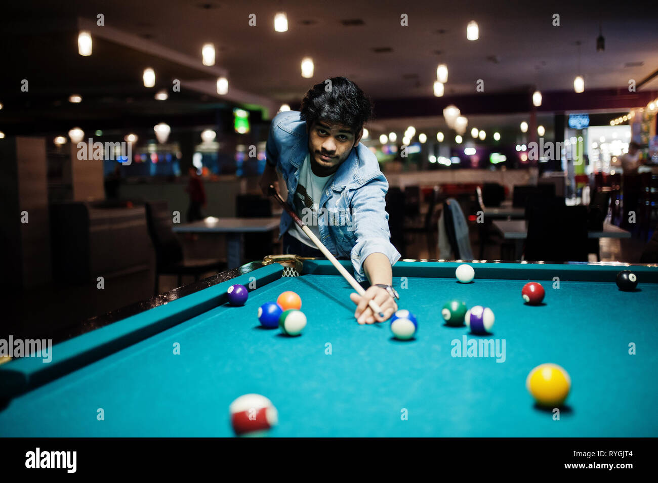 Stylish asian man wear on jeans playing pool billiard on bar Stock ...