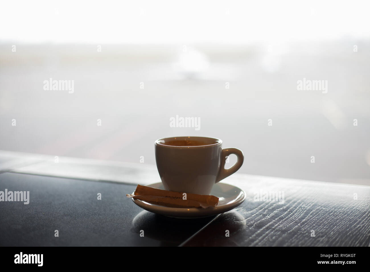 The cup of coffee on the table in airport cafe. View on the aircraft ...