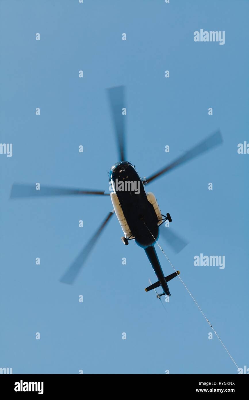 Cargo helicopter with suspended freight on cable. Heavy machinery in ...