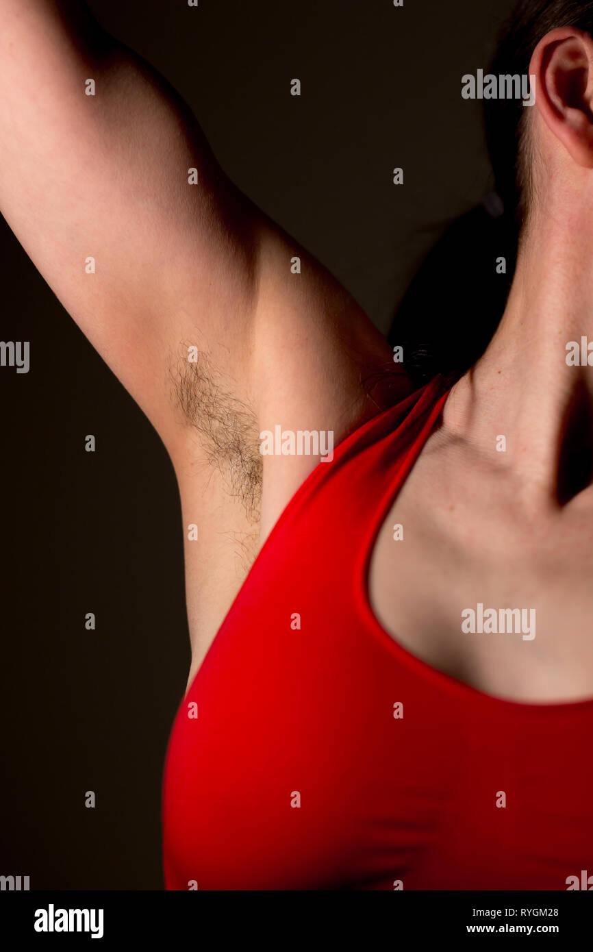 Close-up, portrait, front view of slim, Caucasian woman, in her thirties, with hairy armpits ...