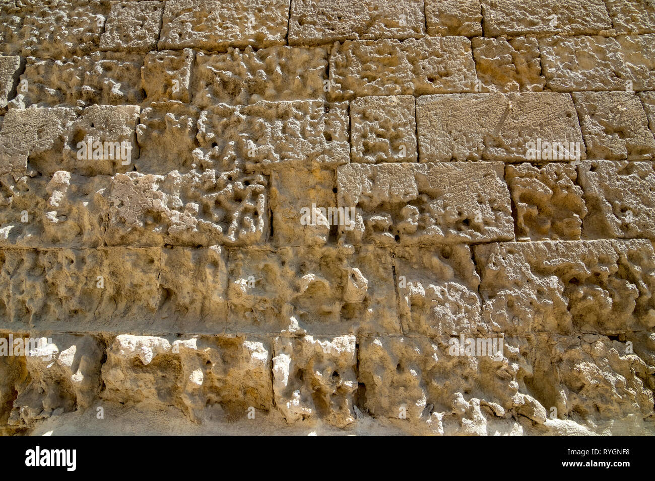 Ancient yellow stone wall with bricks eaten by the rain and time ...