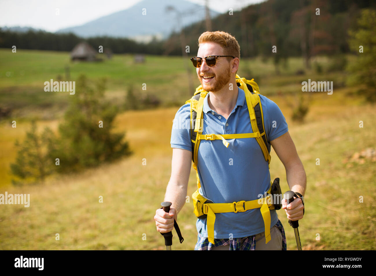 Young hiker enjoys a sunny day on the mountain and walking Stock Photo ...
