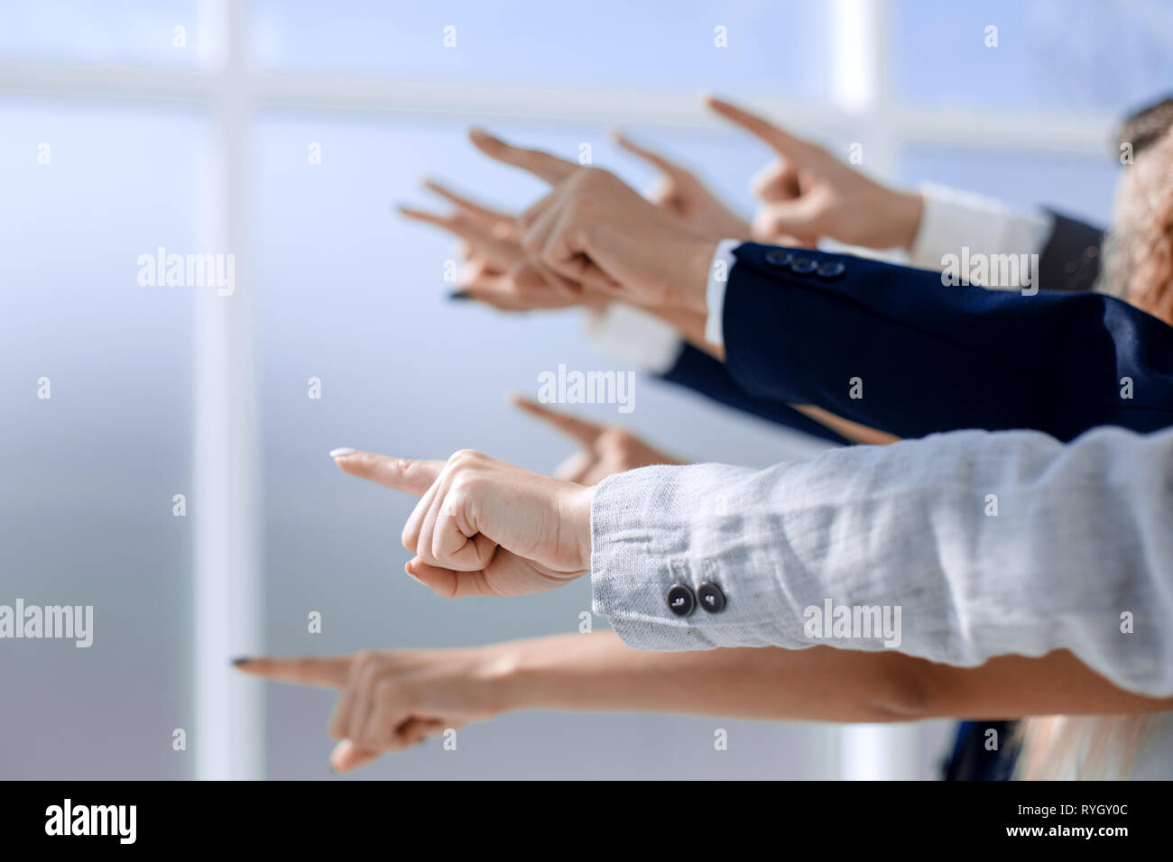 business team pointing to something together Stock Photo - Alamy