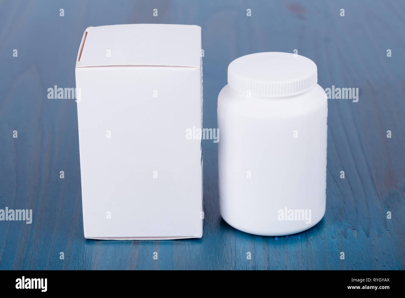 A cardboard box and a white pot on wooden background painted blue Stock ...